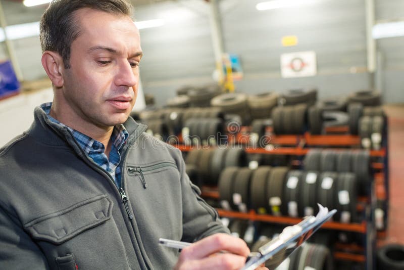 Mechanic with Clipboard at Tyre Shop Stock Photo - Image of maintain ...