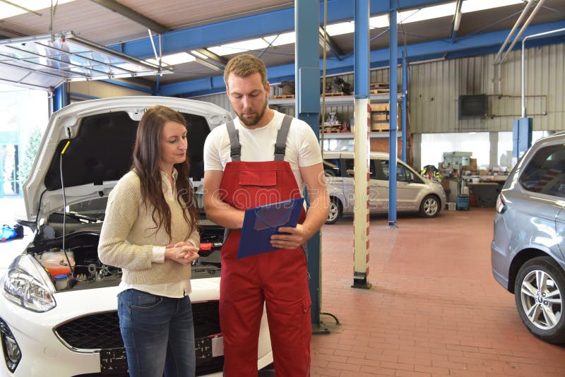 Mechanic and Customer Talking in a Workshop To Repair a Vehicle Stock ...