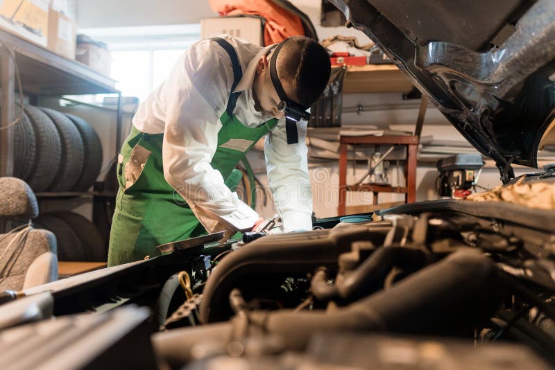 Mechanic Diagnosing an Engine Issue in a Garage Workshop Stock Image ...