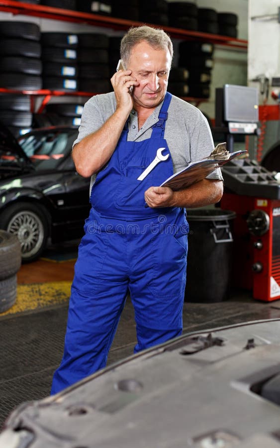 Mechanic Discussing with Client on Phone Stock Image - Image of elderly ...