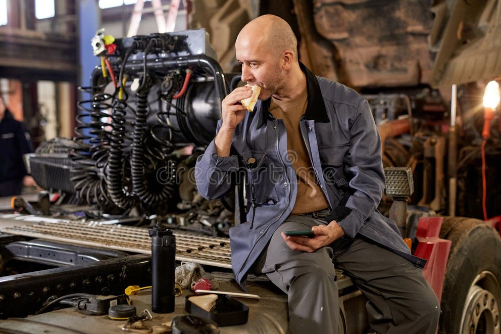 Mechanic Eating Snack during Break in Auto Workshop Stock Photo - Image ...