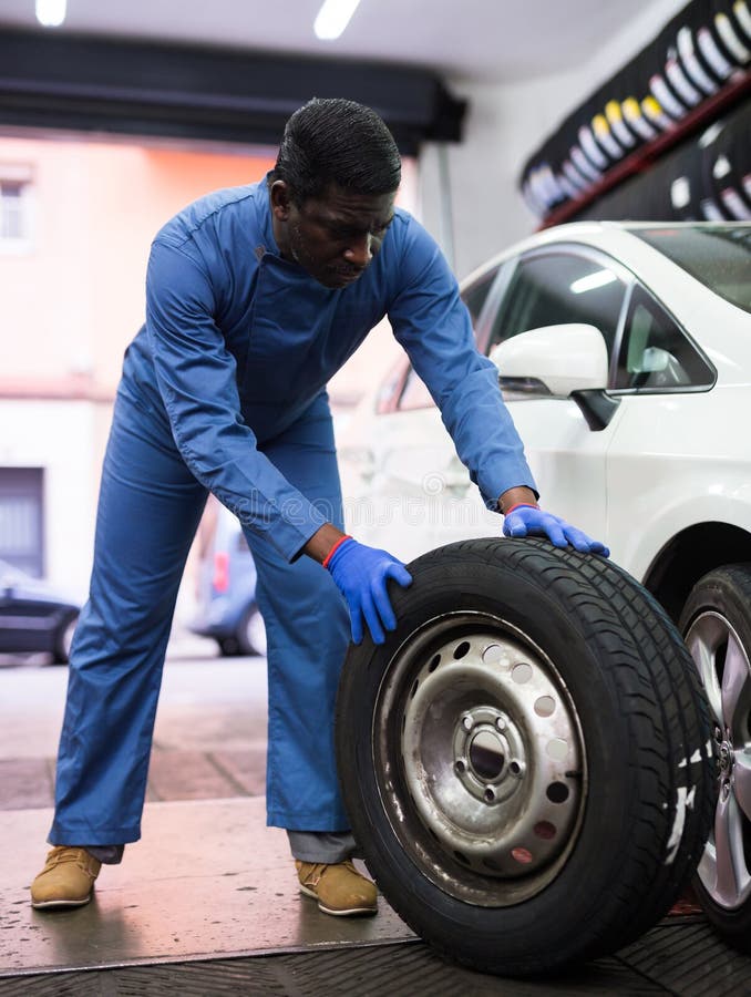 Mechanic Engaged in Replacement of Tyre on Car Wheel in Workshop Stock ...
