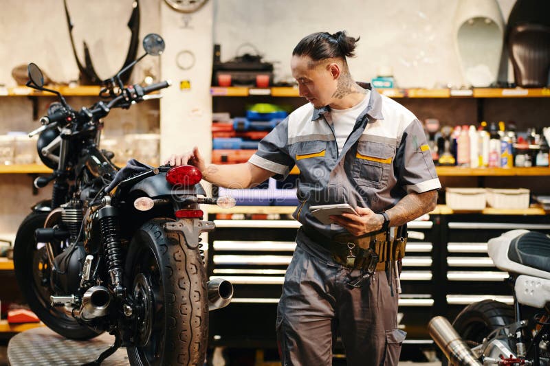 Mechanic Examining Motorcycle Stock Photo - Image of male, technician ...