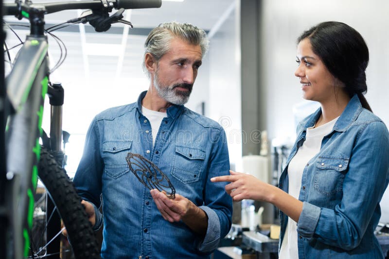 Mechanic with Female Apprentice Looking at Off-road Bicycle Part Stock ...