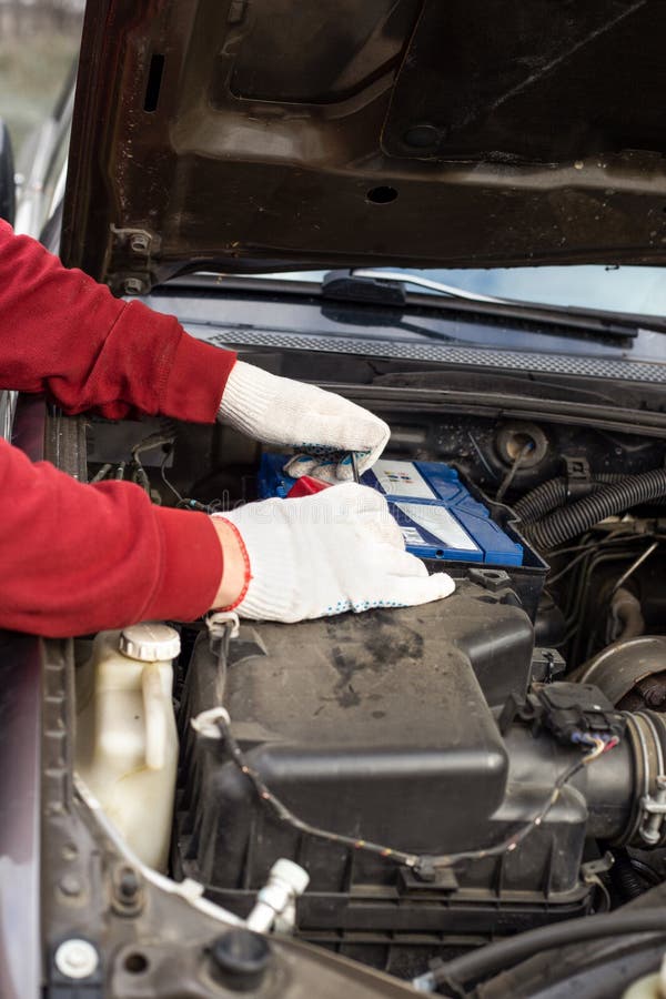The Mechanic Fixes the Car Battery with a Wrench. Battery Replacement ...