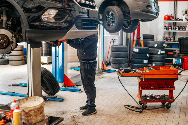 Mechanic Fixing Car Engine on Hydraulic Lift in Garage Workshop Stock ...