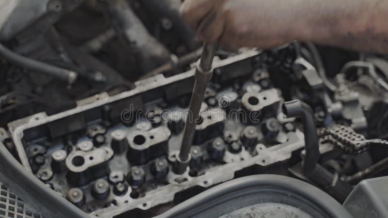 A Mechanic is Fixing a Car Engine in a Workshop, Using Tools for ...