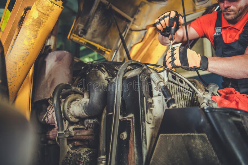 Mechanic Repairing Heavy Machinery Engine in Workshop during Daylight ...