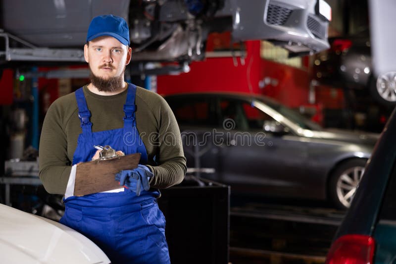 Mechanic Guy Posing with Documents in Car Service Station Stock Image ...
