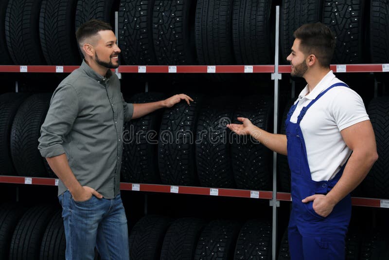 Mechanic Helping Client To Choose Car Tire in Store Stock Photo - Image ...