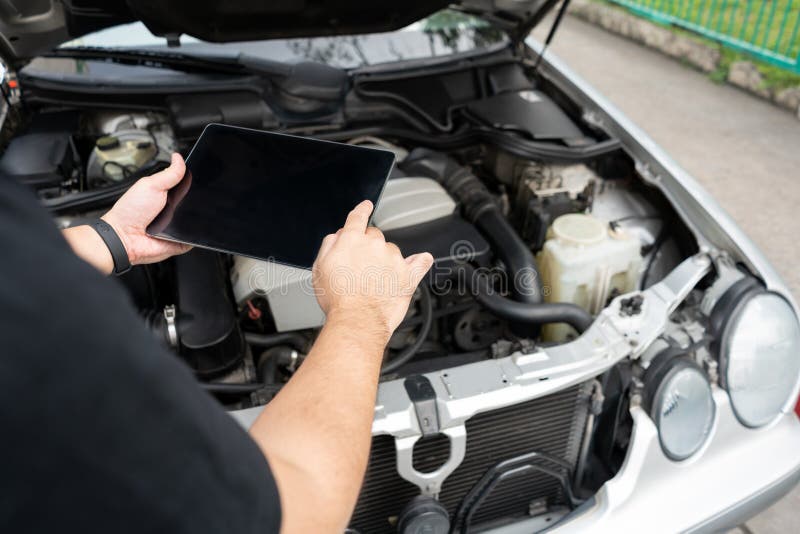 Mechanic Hold Tablet in Hand for Diagnostic or Tune Engine with Smart ...