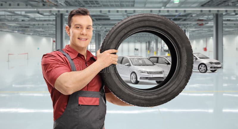 Mechanic Holding a Tire in a Garage Stock Image - Image of technician ...