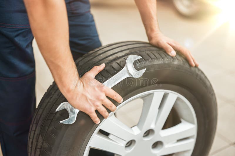 Mechanic Holding Tyre and Car Spanner in His Hand Close Up Stock Photo ...
