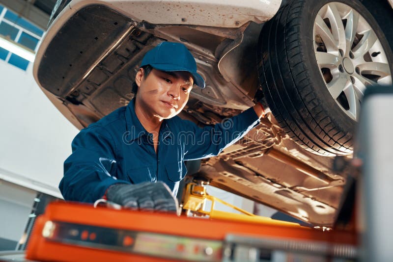Mechanic inspecting car stock photo. Image of asian - 122871694