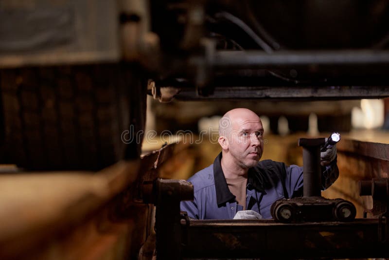 Mechanic Inspecting Underneath Vehicle with Flashlight Stock Image ...