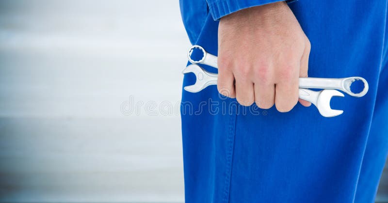 Mechanic Legs and Tools in Hand Against Blurry Grey Wood Panel Stock ...