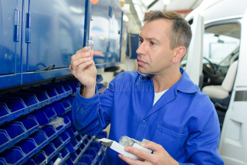 Mechanic looking for parts stock image. Image of young - 123022935