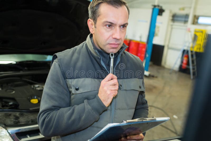 Mechanic Looking at Screen in Garage Stock Photo - Image of design ...