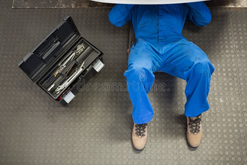 Mechanic Lying Down and Working Under Car at Auto Service Garage ...