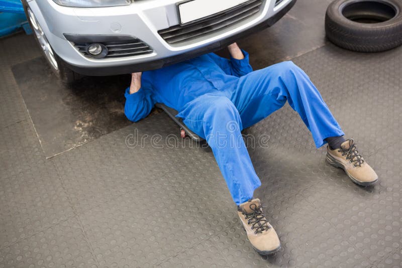 Mechanic Lying Down and Working Under Car at Auto Service Garage ...