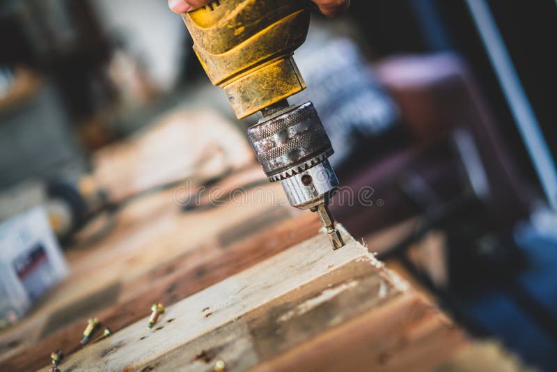 The Mechanic, the Man, is Using a Drill To Drill Wood . Stock Photo ...