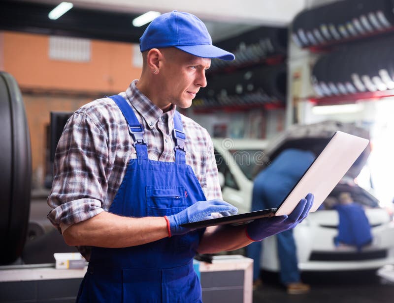 Mechanic Man Using Laptop Checking Car in Workshop Stock Photo - Image ...