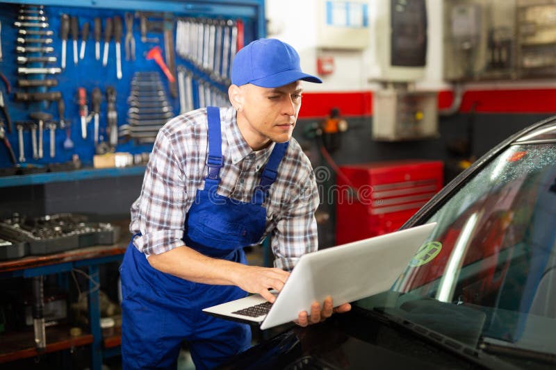 Mechanic Man Using Laptop Checking Car in Workshop Stock Photo - Image ...