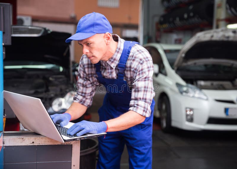 Mechanic Man Using Laptop Checking Car in Workshop Stock Photo - Image ...