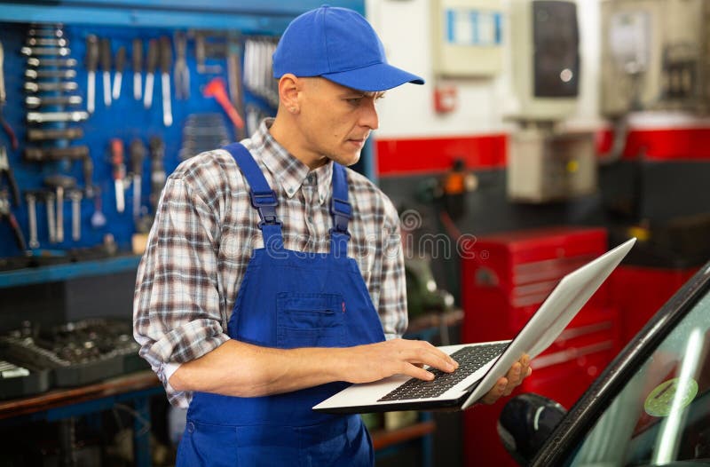 Mechanic Man Using Laptop Checking Car in Workshop Stock Image - Image ...