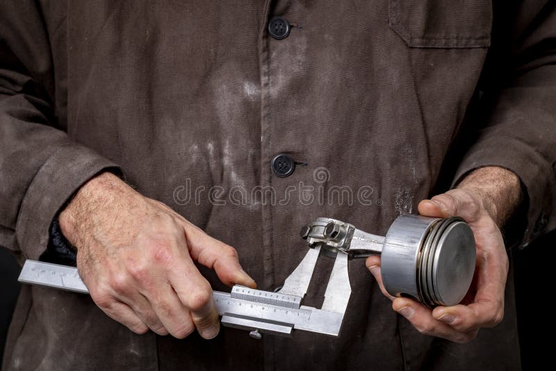 A Mechanic Measuring the Piston of an Internal Combustion Engine. Work ...