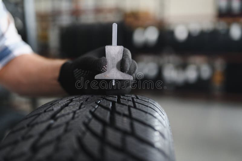 Mechanic Measuring Tire Tread Depth in Automobile Service Centre Stock ...