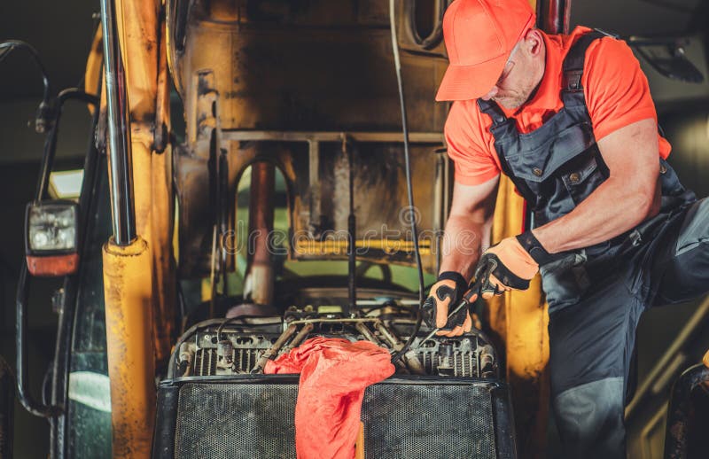 Mechanic Repairing Heavy Machinery in Workshop during Daytime with ...