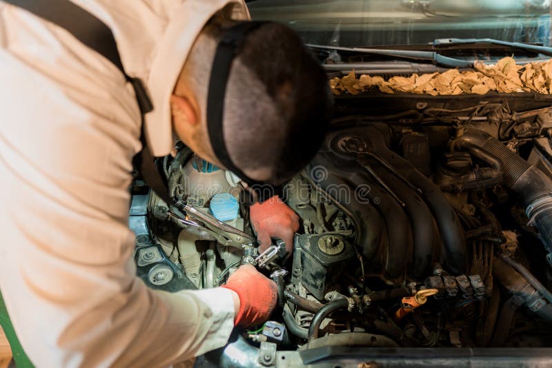 Mechanic Performing Detailed Engine Repair in a Workshop Stock Image ...