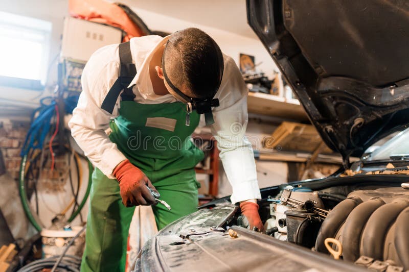 Mechanic Performing Maintenance on Car Engine in Workshop Stock Photo ...