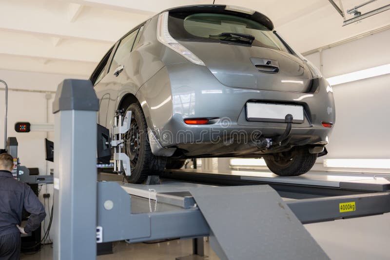 Mechanic Performs Precise Wheel Alignment on a Modern Electric Vehicle ...