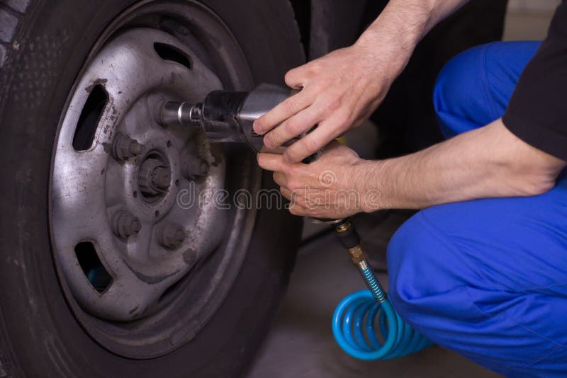 Mechanic is Pumping Up Wheels in Service Station Stock Photo - Image of ...