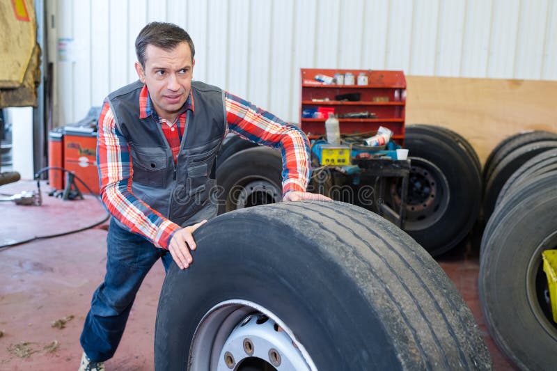 Mechanic Pushing Heavy Lorry Wheel Stock Image - Image of push, pile ...