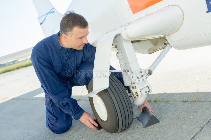 Mechanic Putting Chocks Around Wheel Aircraft Stock Photo - Image of ...