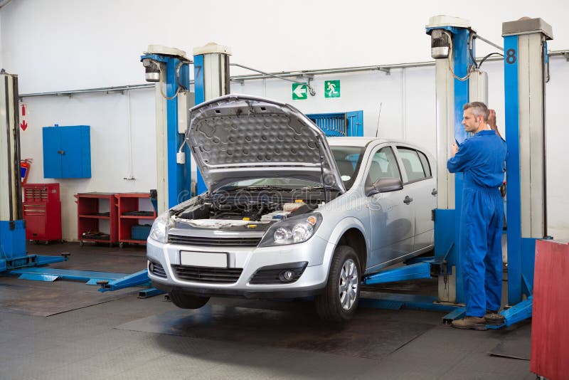 Mechanic Raising the Car with a Workshop Jack Stock Image - Image of ...
