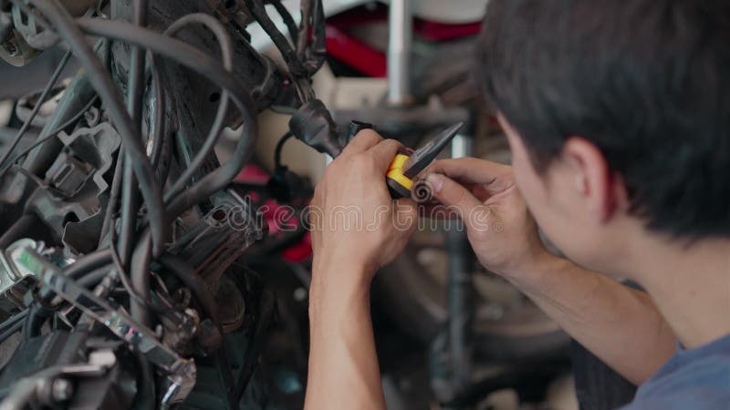 Mechanic Repair or Wiring Motorcycle in Garage. Repair or Maintenance ... Mechanic Repair or Wiring Motorcycle in Garage. Repair or Maintenance ...
