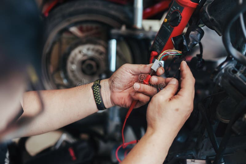 Mechanic Repair or Wiring Motorcycle in Garage. Repair or Maintenance ... Mechanic Repair or Wiring Motorcycle in Garage. Repair or Maintenance ...