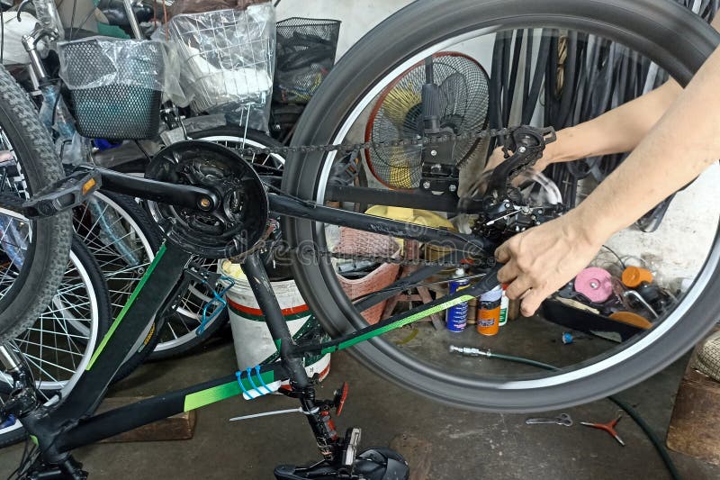 A Mechanic is Repairing a Bicycle Wheel and Chain Stock Image - Image ...