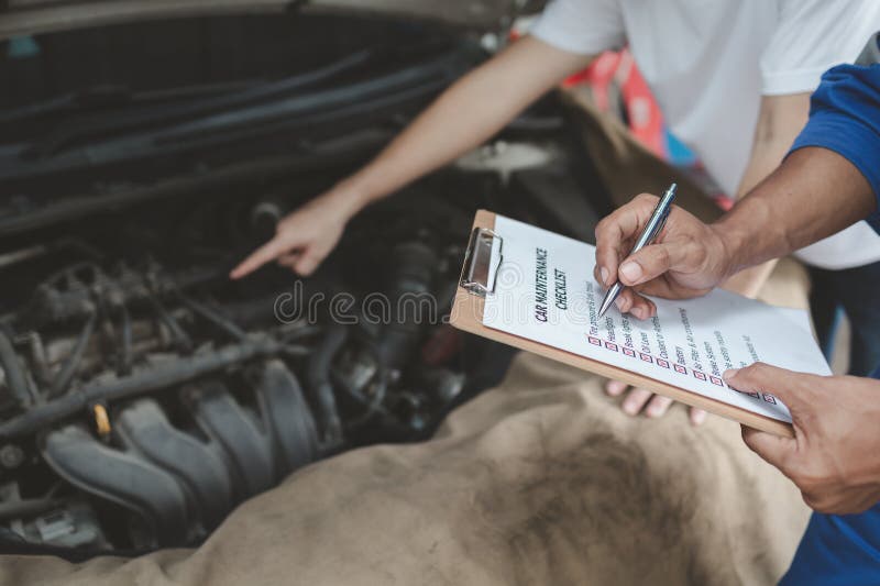 The Mechanic is Repairing the Engine, a Car Repair Worker is Inspecting ...