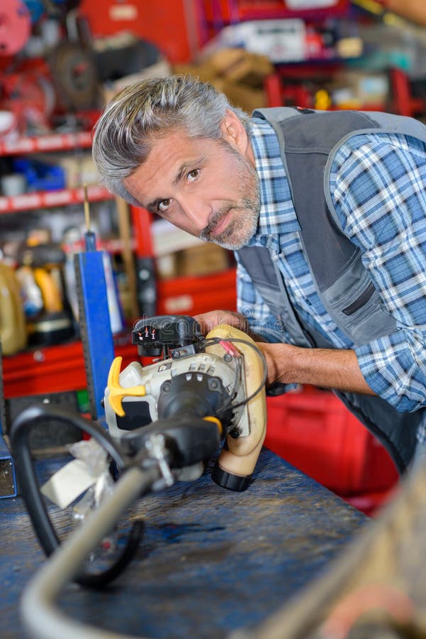 Mechanic repairing trimmer stock photo. Image of broken - 298849730