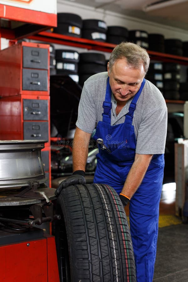 Mechanic Replacing Tyre on Car Wheel Stock Photo - Image of repairing ...