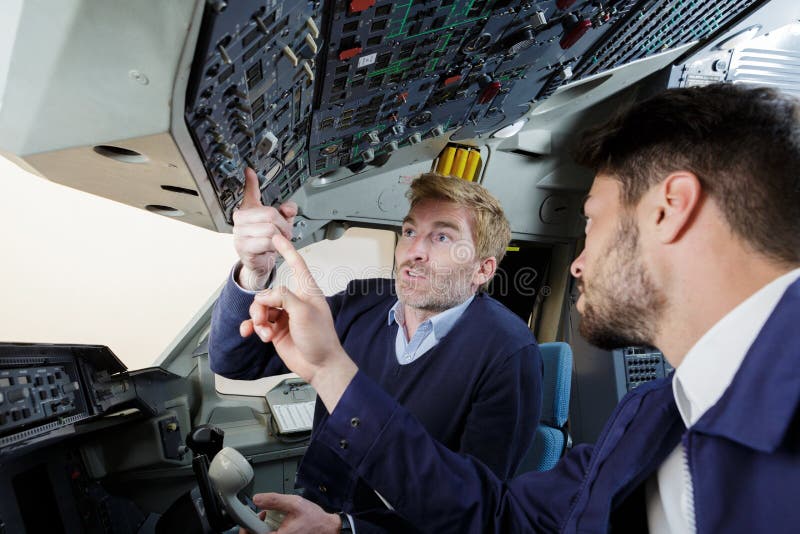 Mechanic Showing Young Men Inside Cockpit Stock Photo - Image of ...