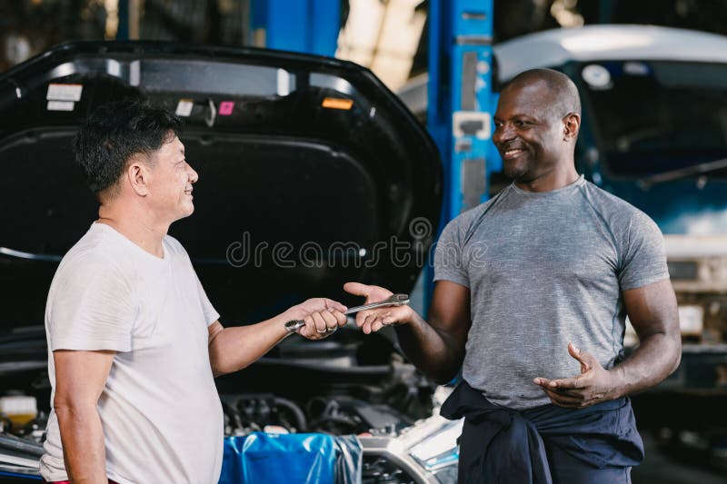 Mechanic Team Men Working Together To Service Fix Engine Problem in Car ...