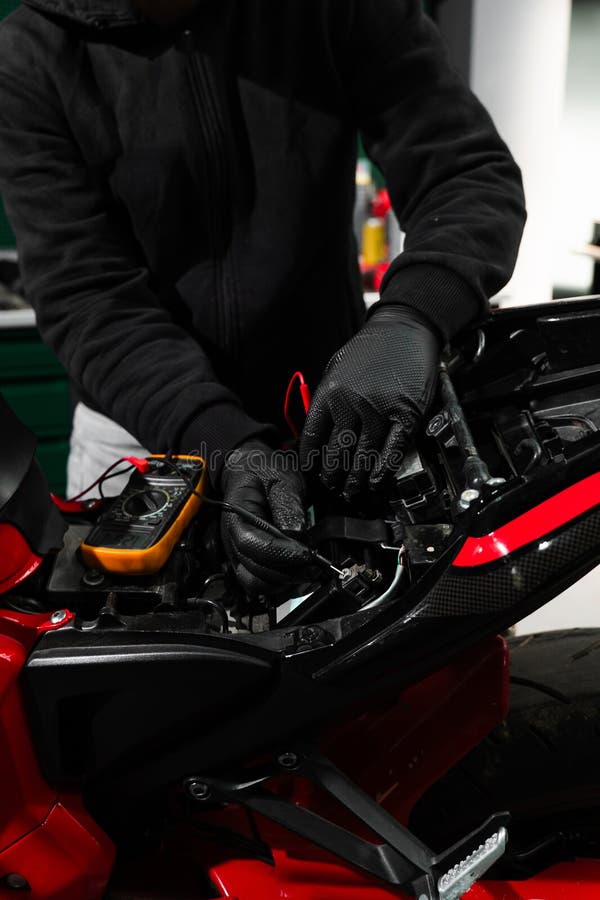 Mechanic Testing Battery with Multimeter. Motorcycle Battery is Tested ...