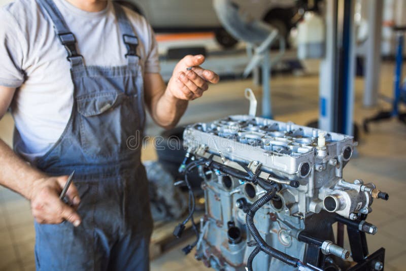 Mechanic with a Tool in His Hands Repairing the Motor of the Machine ...