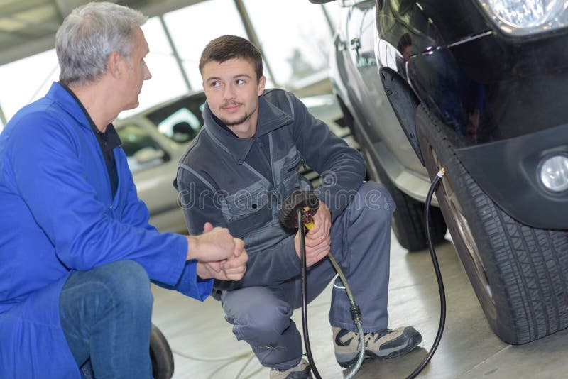 Mechanic and Trainee Working on Car Together Stock Photo - Image of ...